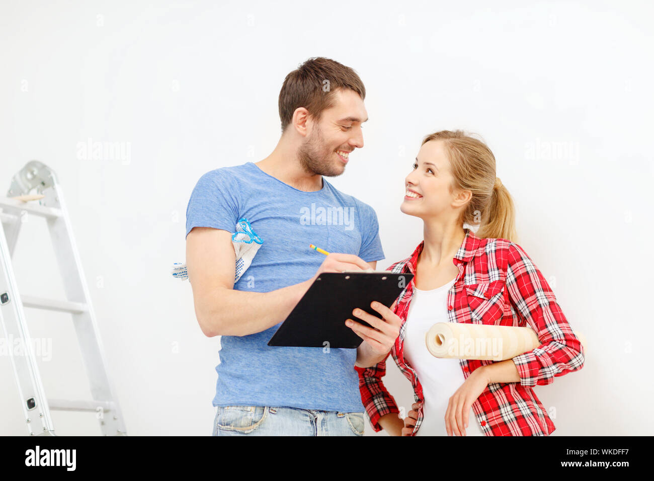 repair, building and home concept - smiling couple with clipboard ...