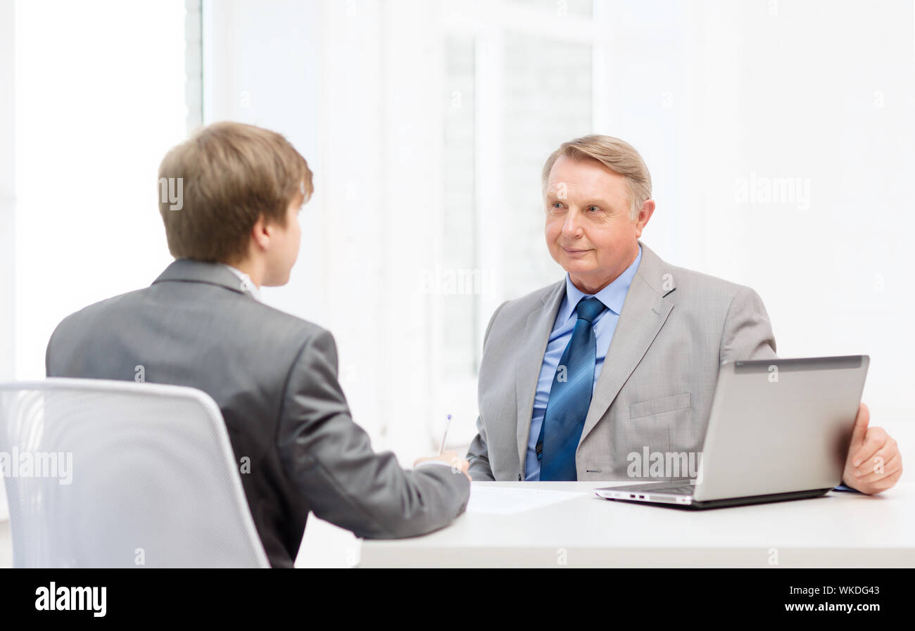 business, technology and office concept - older man and young man ...