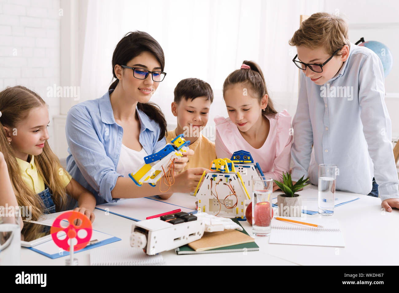 School children constructing robots with teacher in class Stock Photo ...