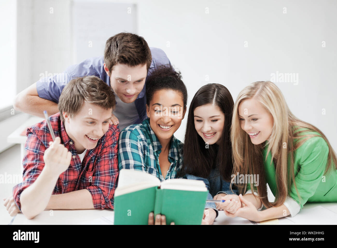 education concept - students reading book at school Stock Photo - Alamy