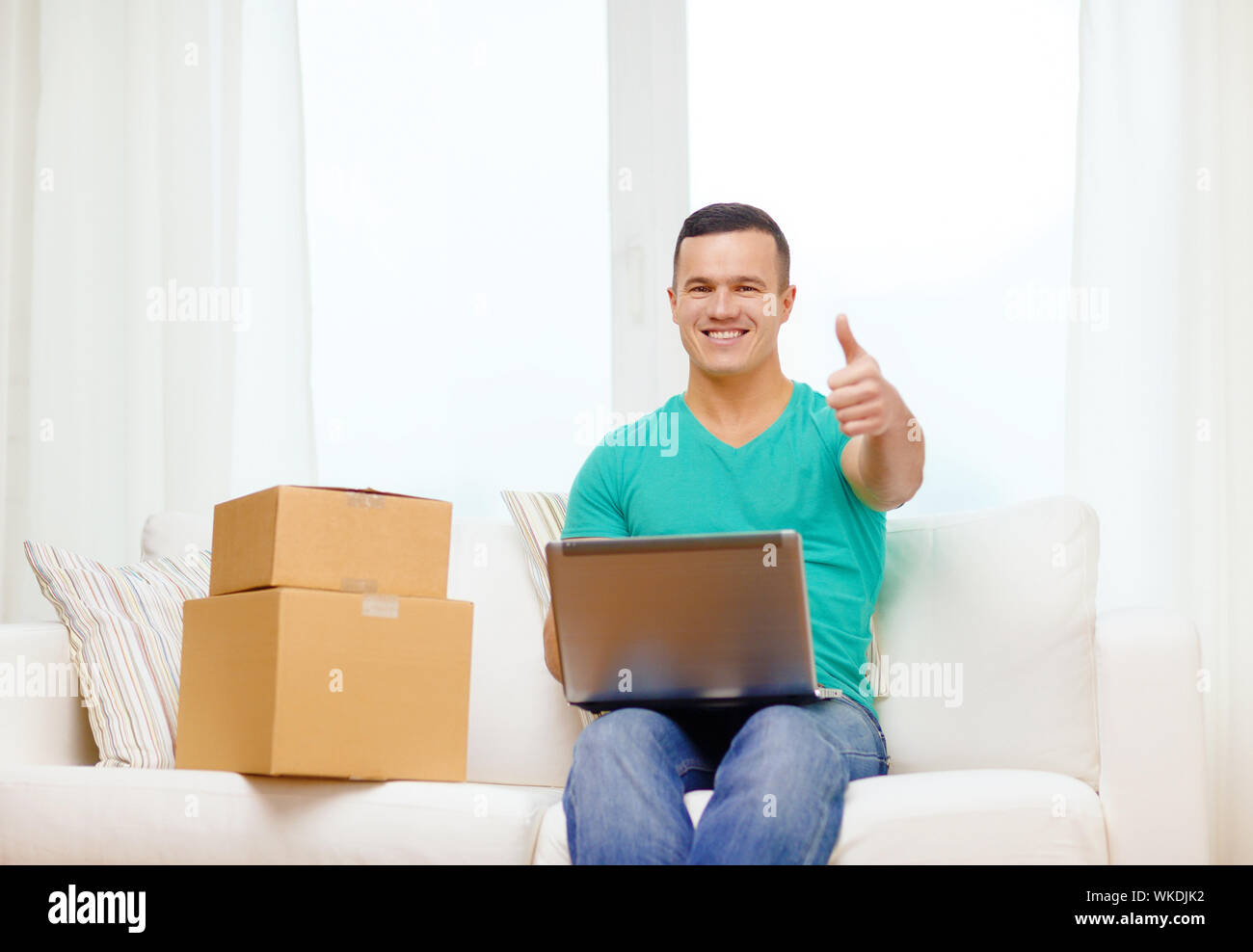 man with laptop and cardboard boxes at home Stock Photo - Alamy