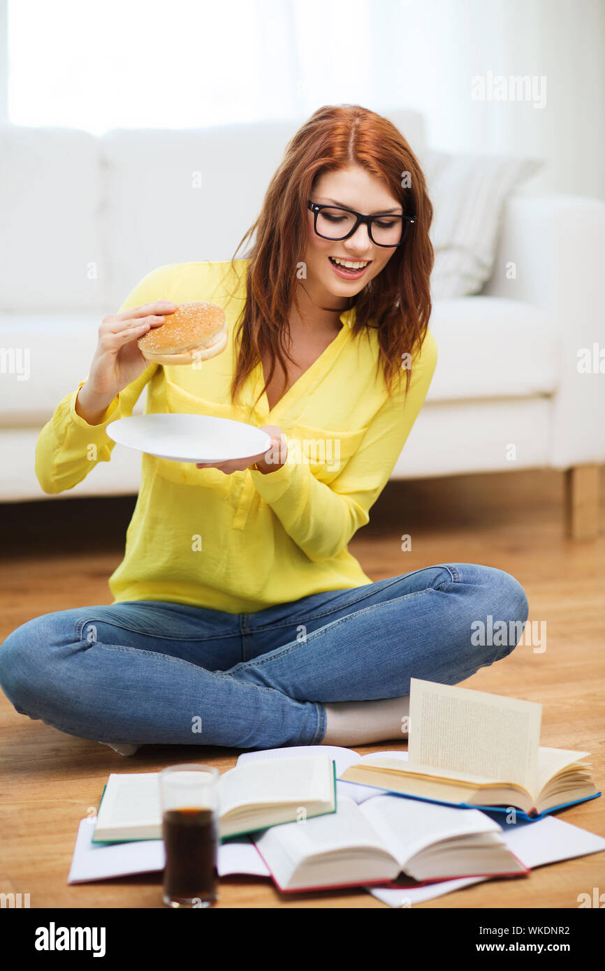 student eating hamburger and doing homework Stock Photo - Alamy
