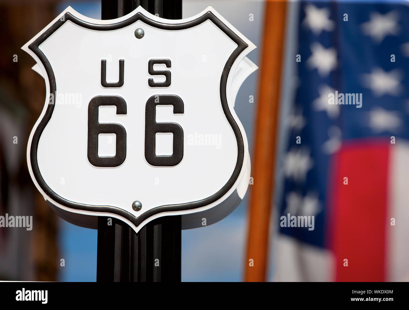Route 66 sign on side of road with American flag Stock Photo - Alamy