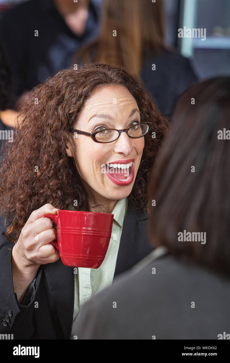 Surprised woman laughing with friend in coffee house Stock Photo - Alamy