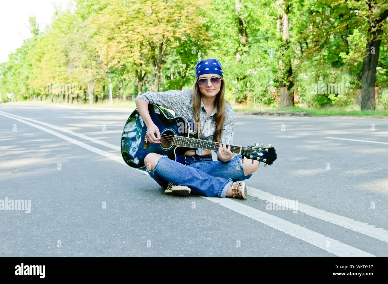 Rocking girl on a highway road with guitar Stock Photo - Alamy