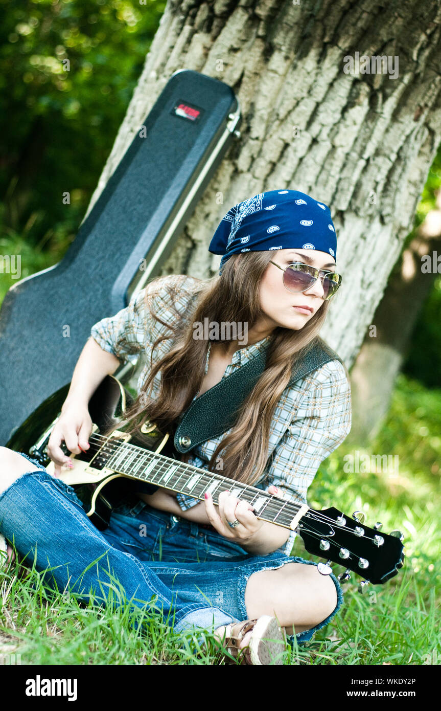Rocking girl on a nature with guitar Stock Photo - Alamy