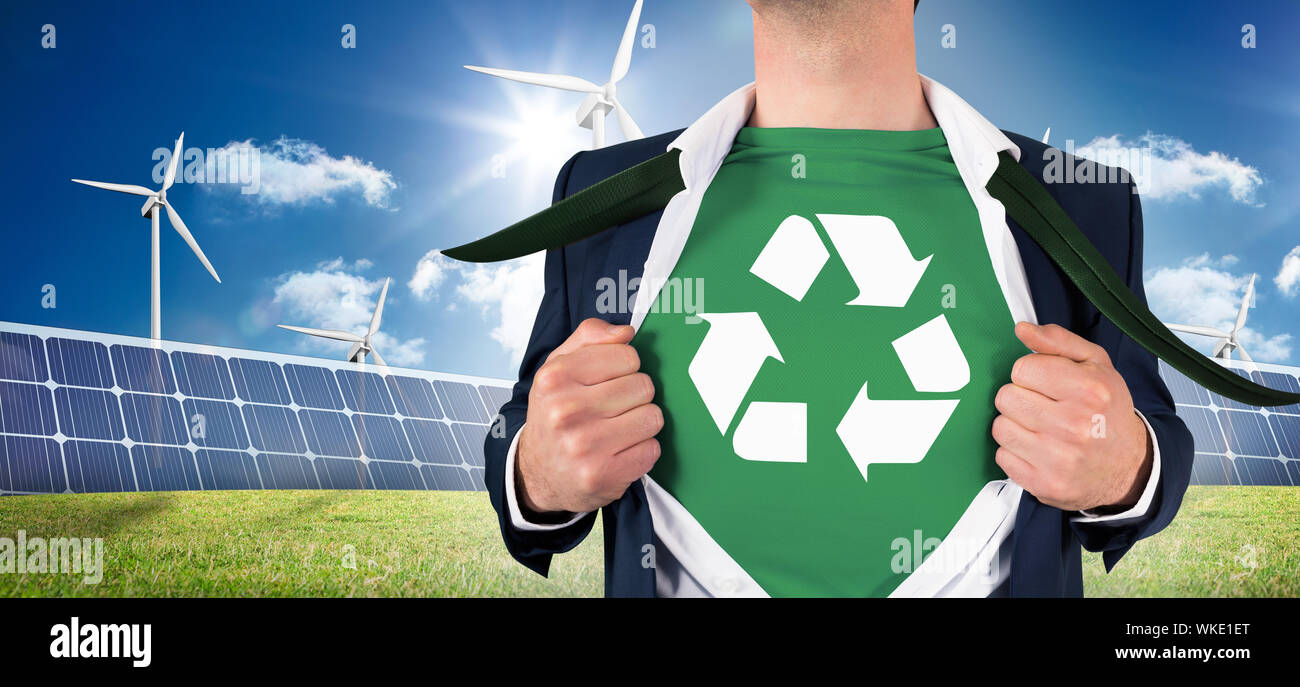 Businessman opening shirt in superhero style against large solar panel ...