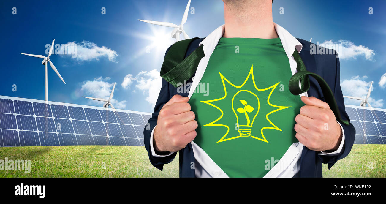 Businessman opening shirt in superhero style against large solar panel ...