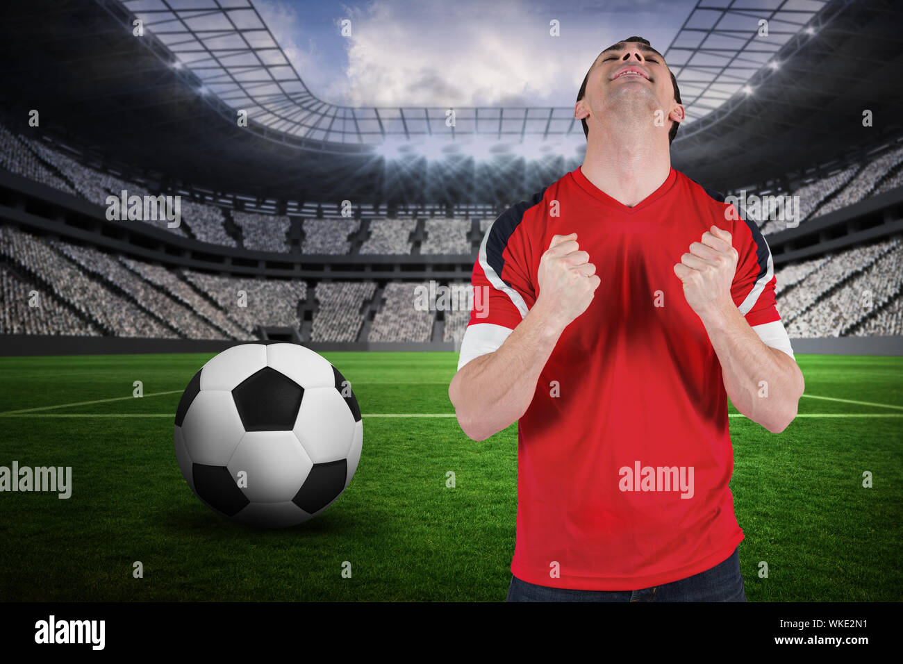 Excited football fan cheering against vast football stadium with fans ...