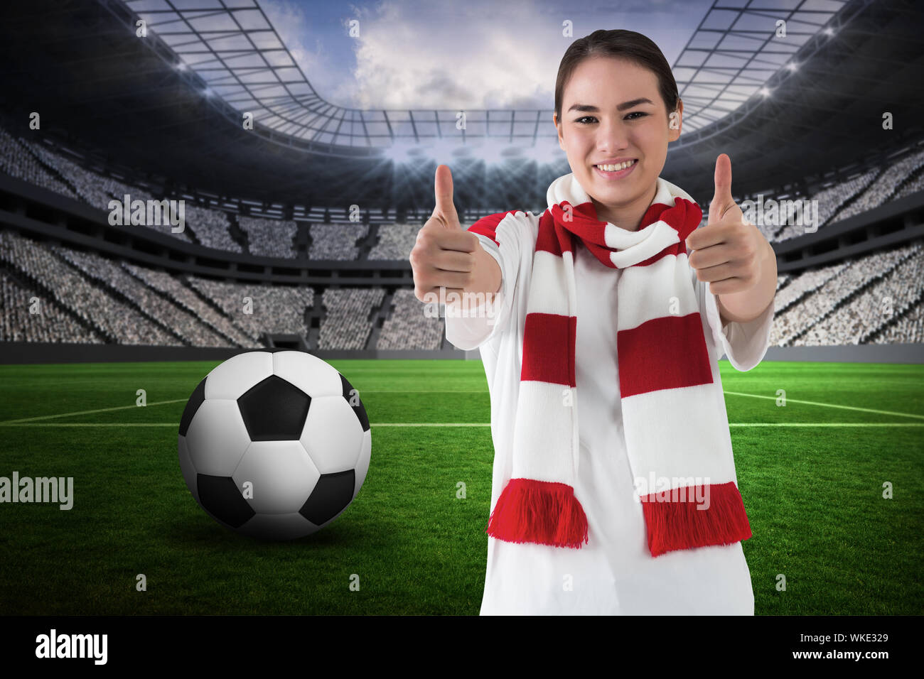 Football fan in white wearing scarf showing thumbs up against vast ...