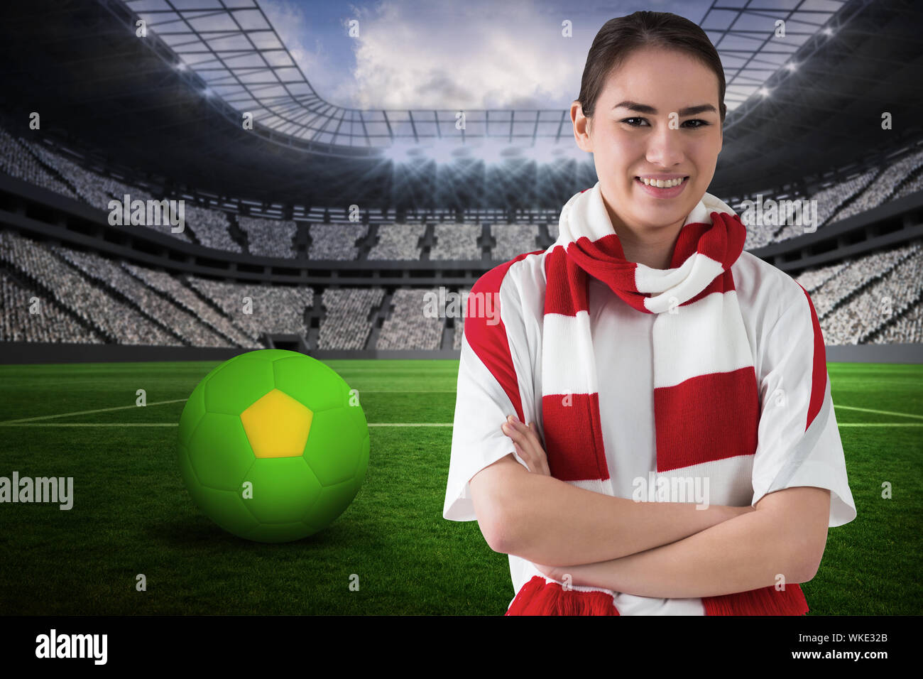 Football fan in white wearing scarf against vast football stadium with ...