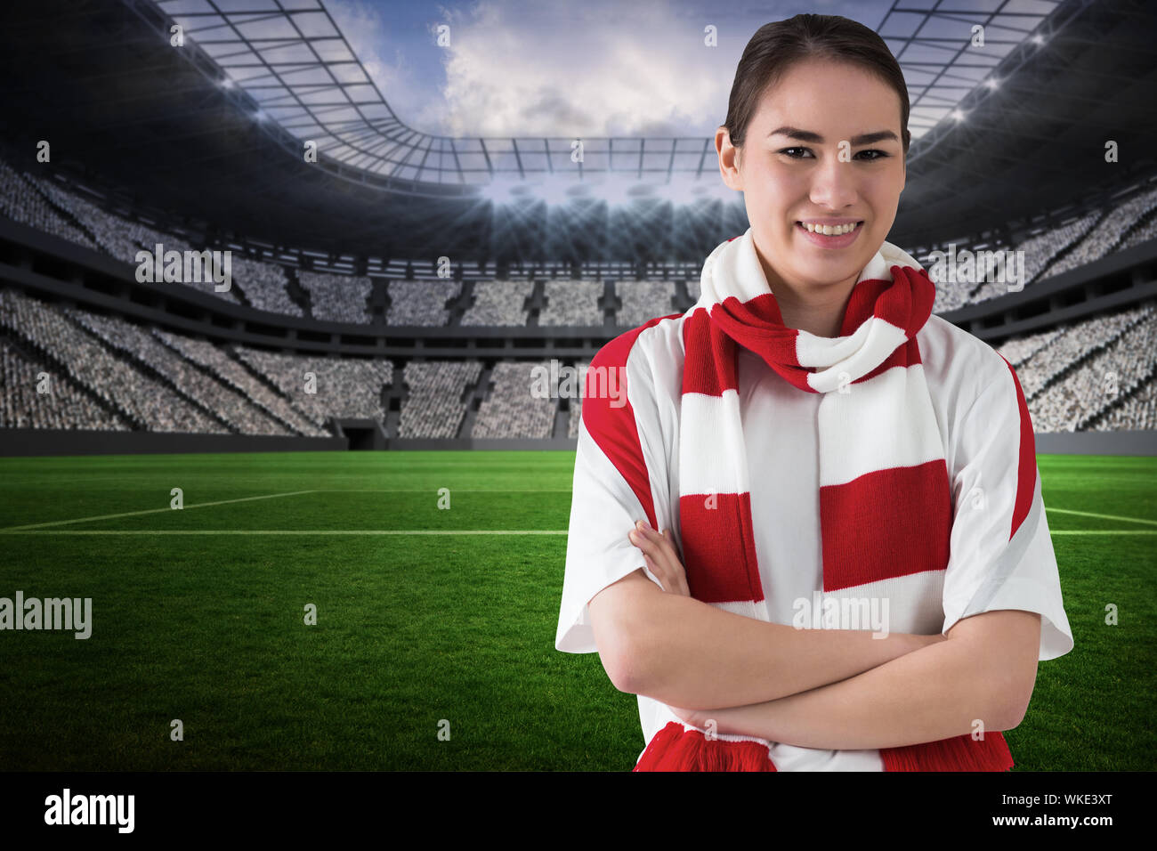 Football fan in white wearing scarf in a vast football stadium with ...