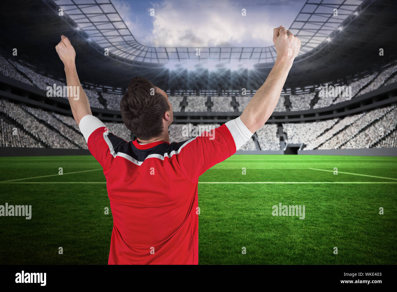 Excited football fan cheering in a vast football stadium with fans in ...
