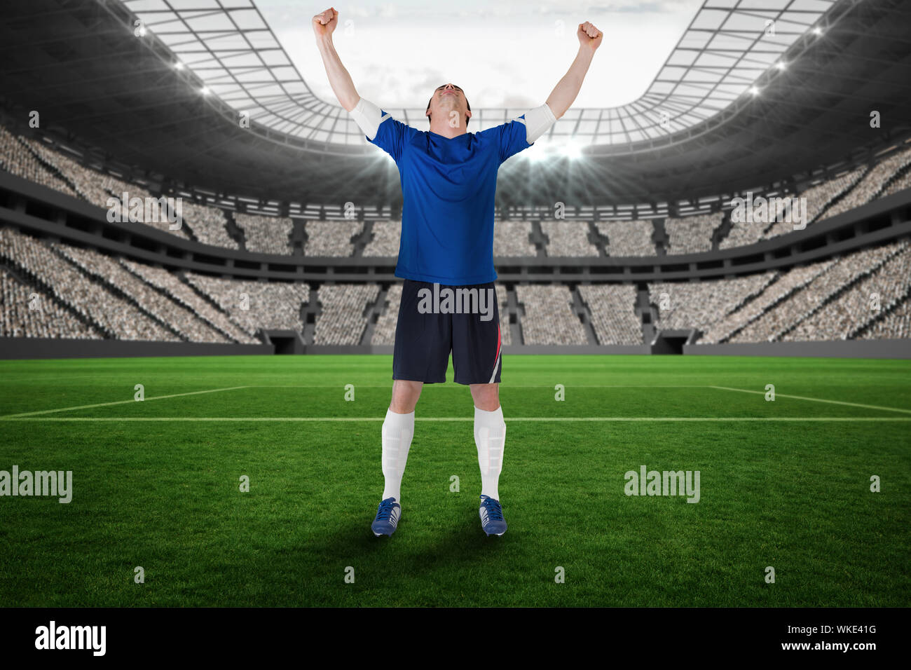 Football player celebrating a win in a vast football stadium with fans ...
