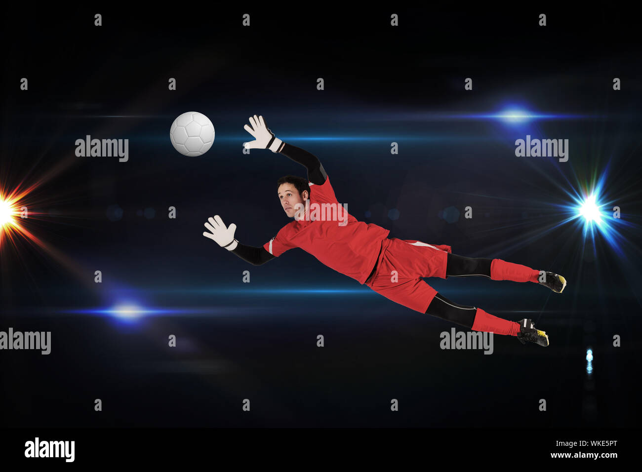 Fit goal keeper jumping up against black background with spark Stock ...