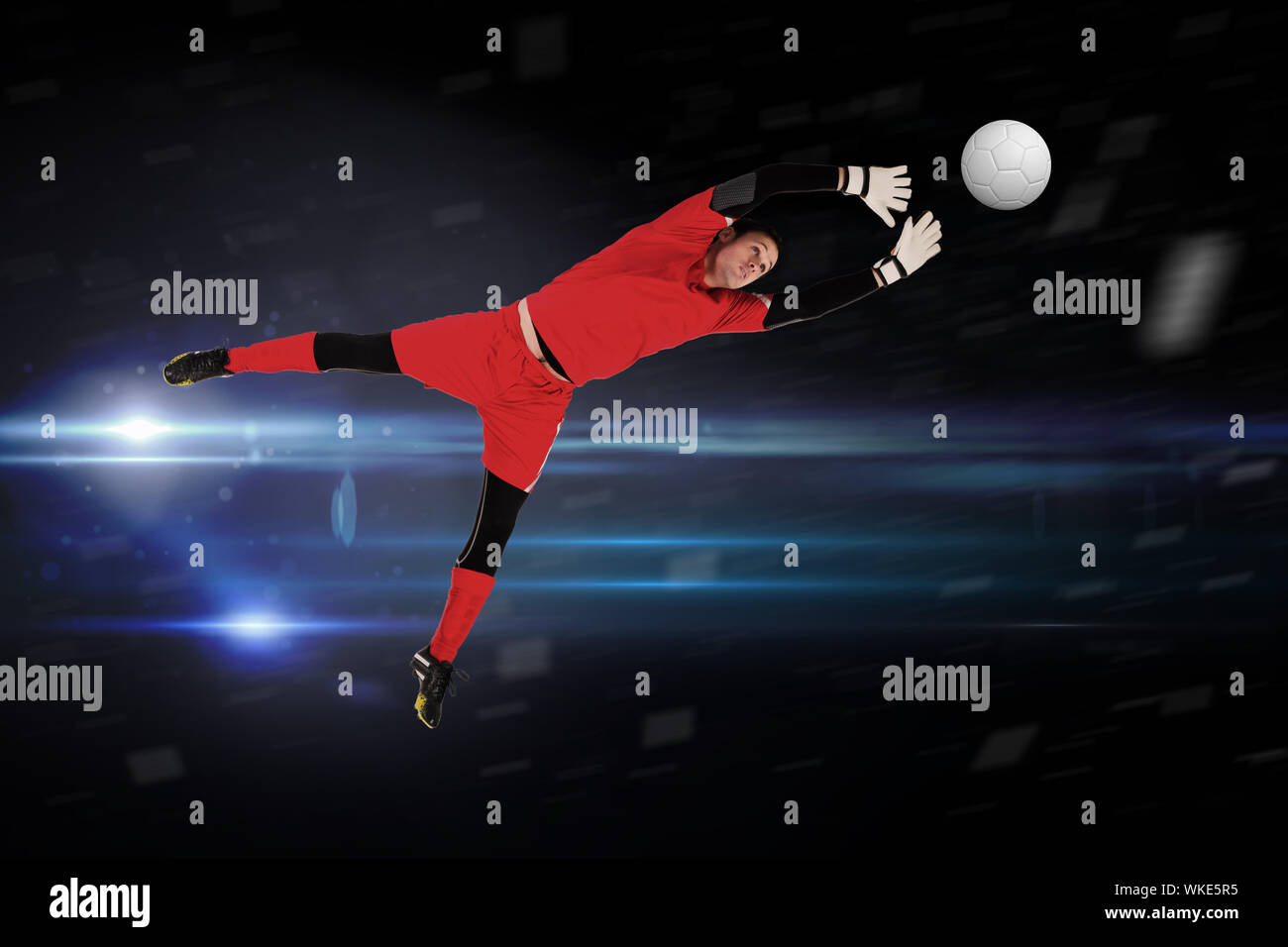 Fit goal keeper jumping up against black background with spark Stock ...