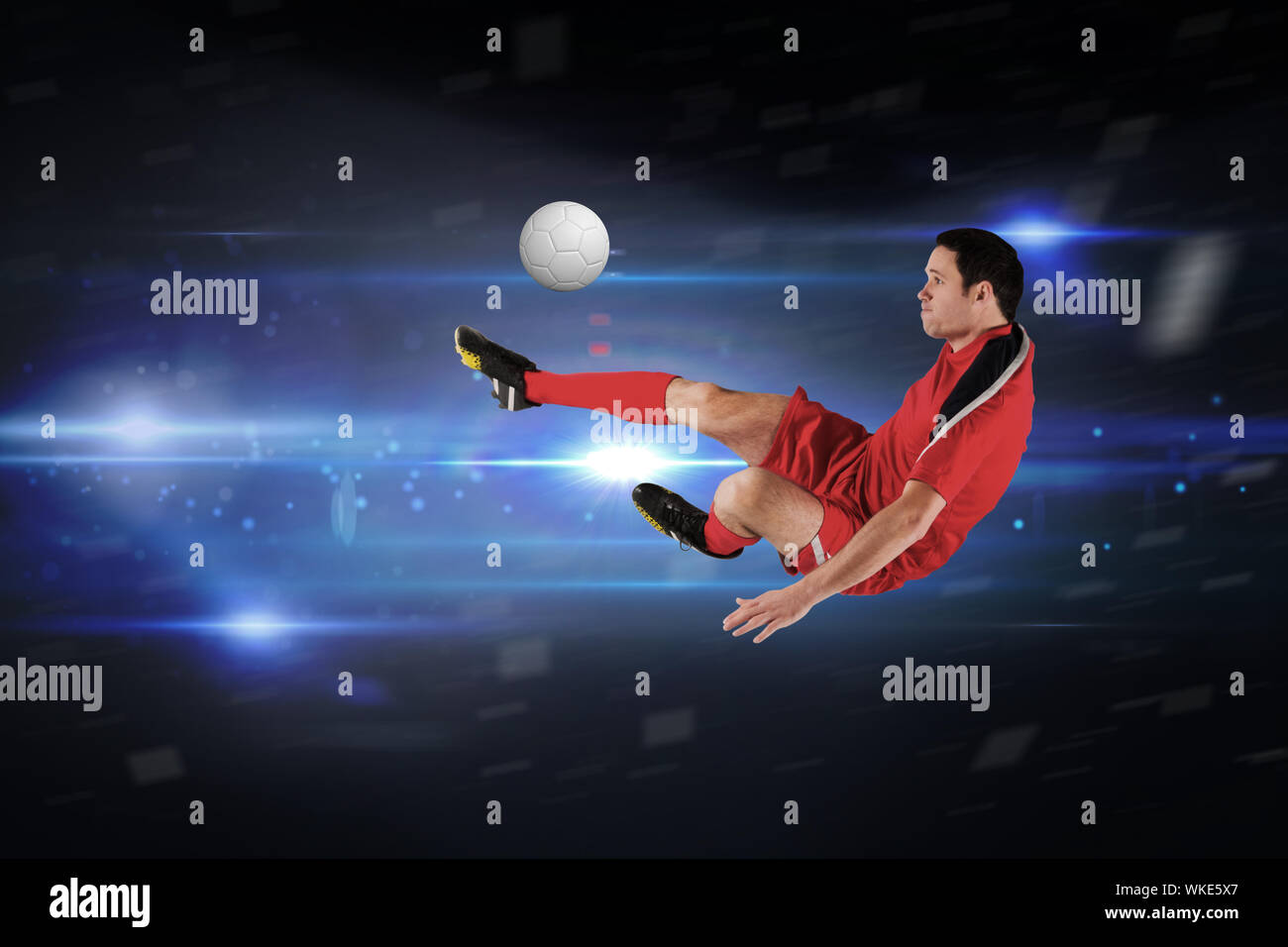 Football player in red kicking against black background with spark ...