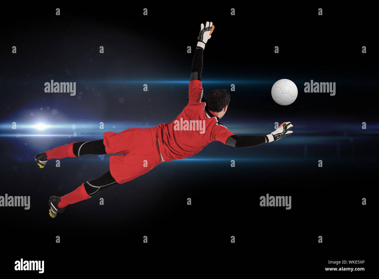 Fit goal keeper jumping up against black background with spark Stock ...