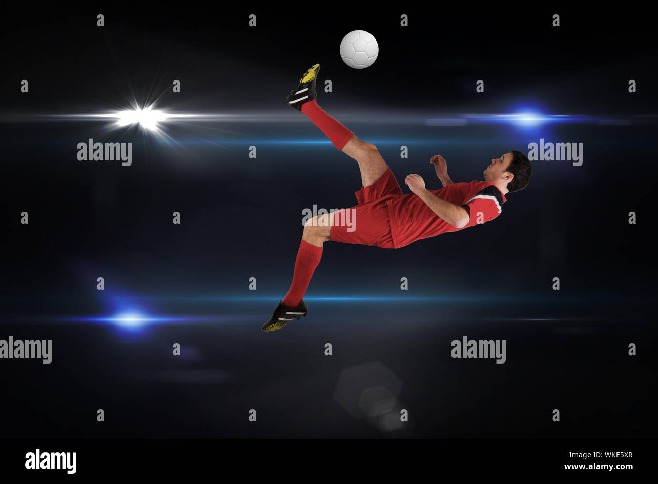 Football player in red kicking against black background with spark ...