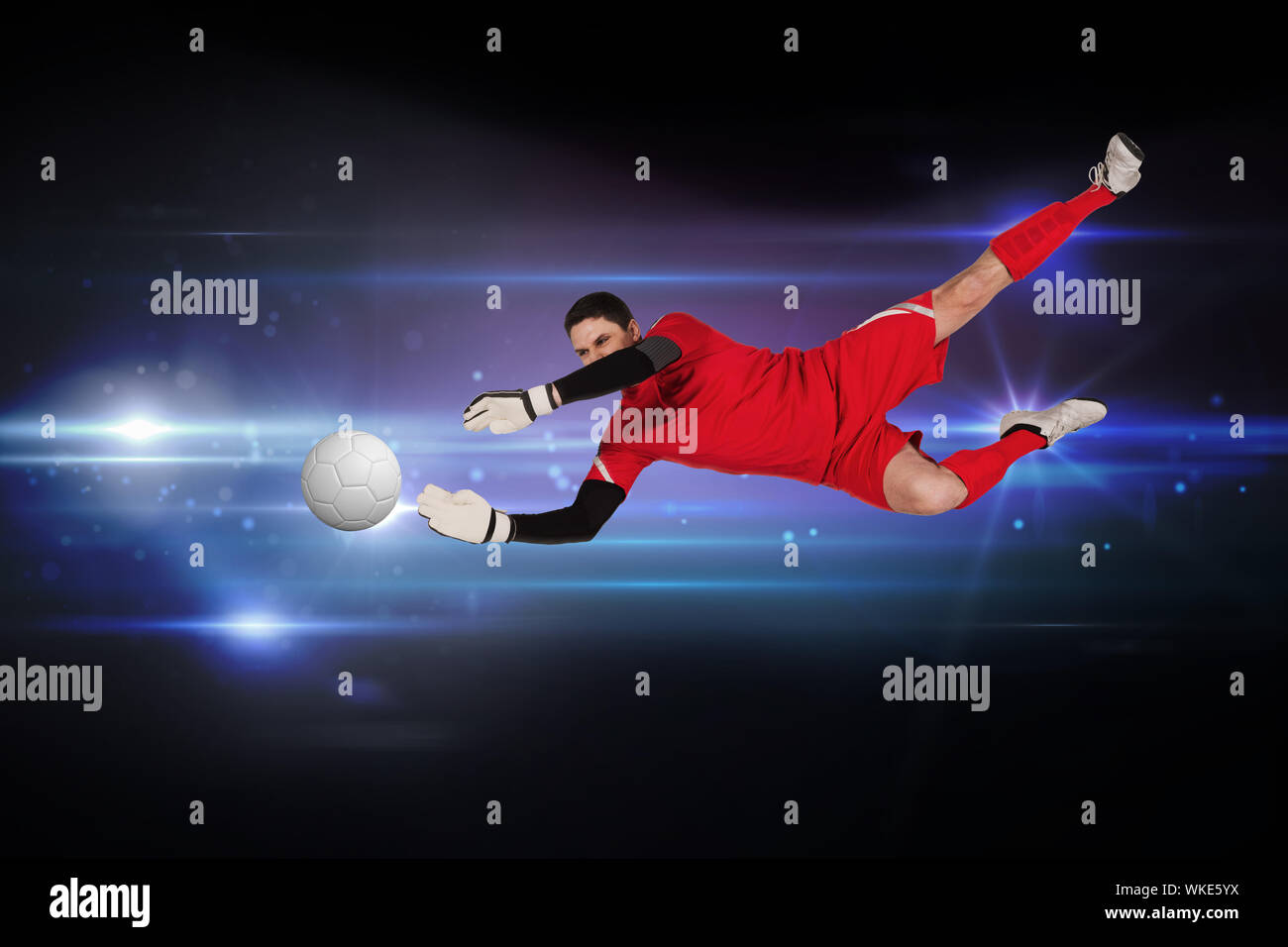 Fit goal keeper jumping up against black background with spark Stock ...