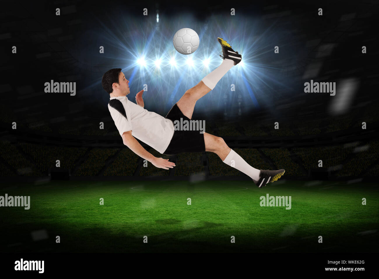 Football player in white kicking against football pitch under ...