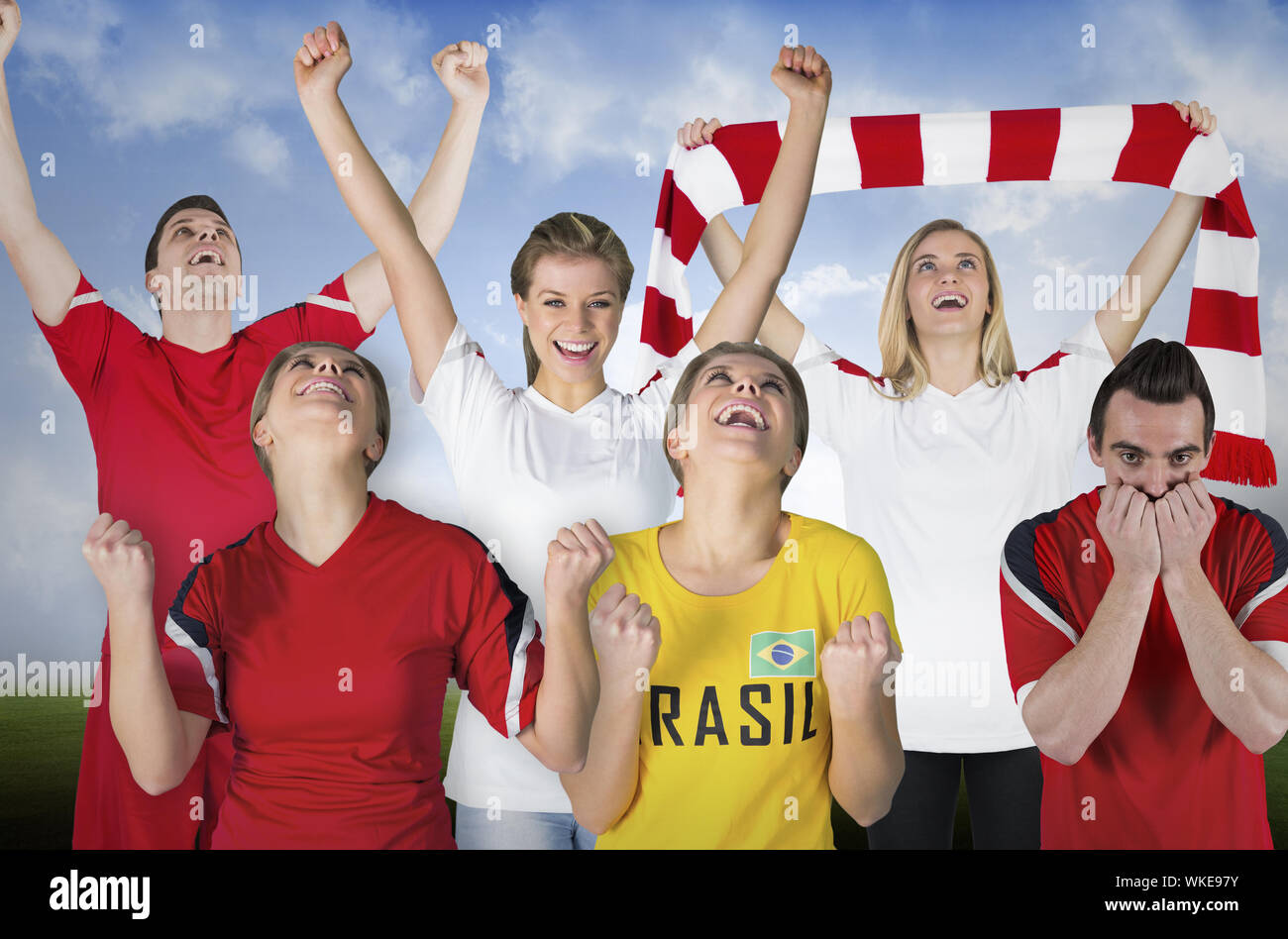 Composite image of various football fans in red against football pitch ...