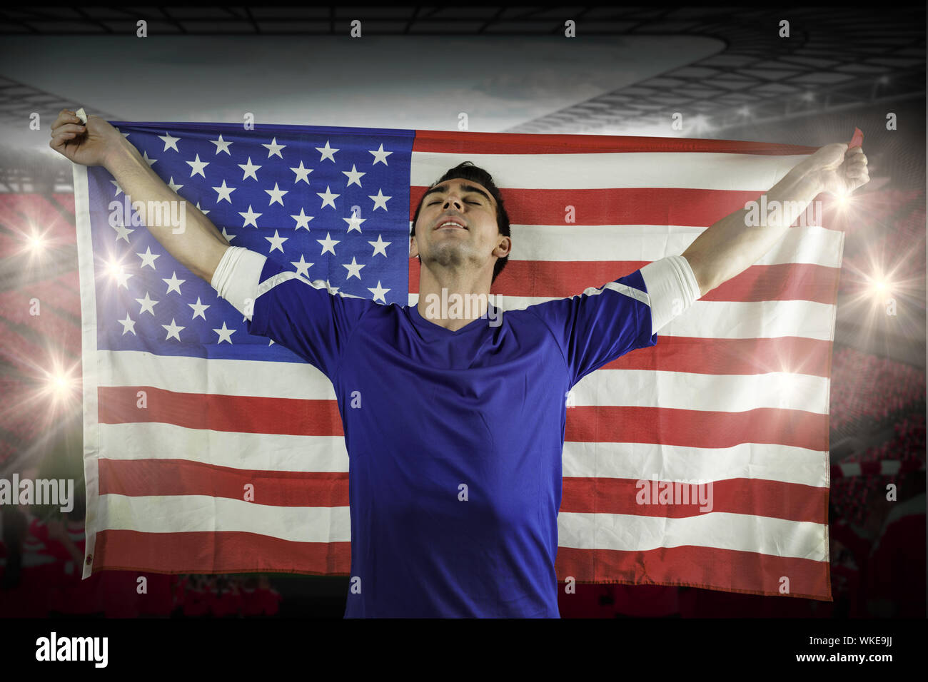 American soccer fan holding flag against vast football stadium with ...