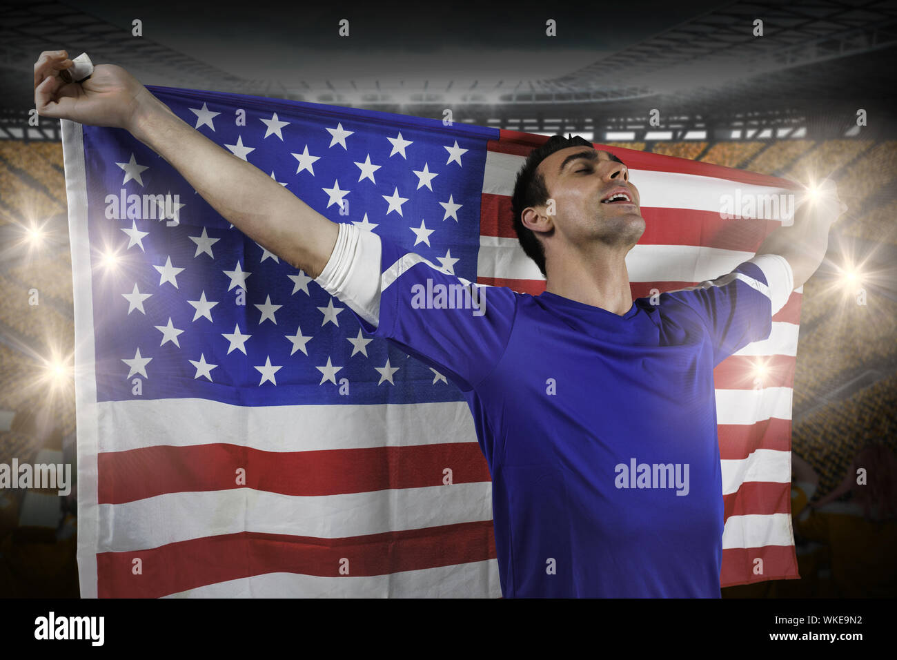 American soccer fan holding flag against vast football stadium with ...
