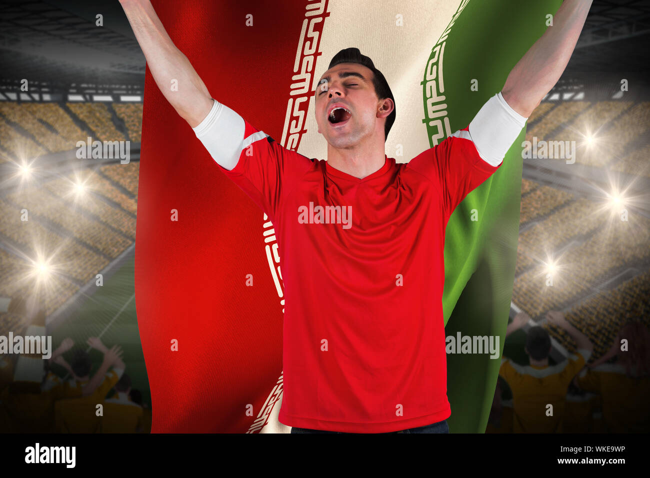 Excited football fan cheering holding iran flag against vast football ...