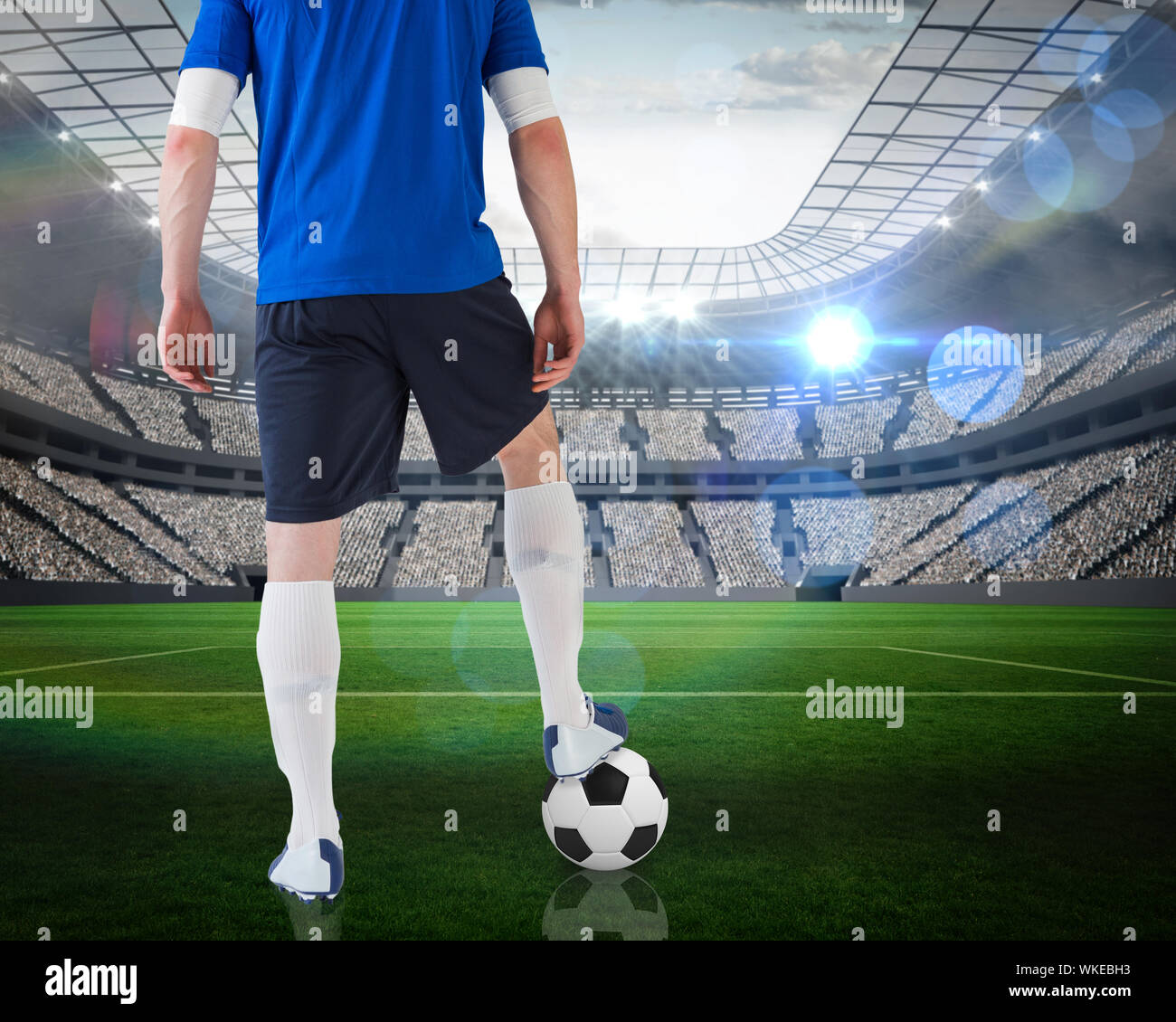Composite image of football player standing with ball against large ...