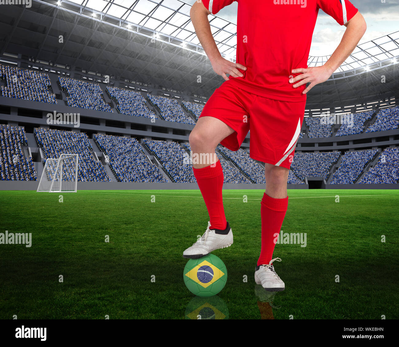 Composite image of football player standing with brasil ball looking at ...