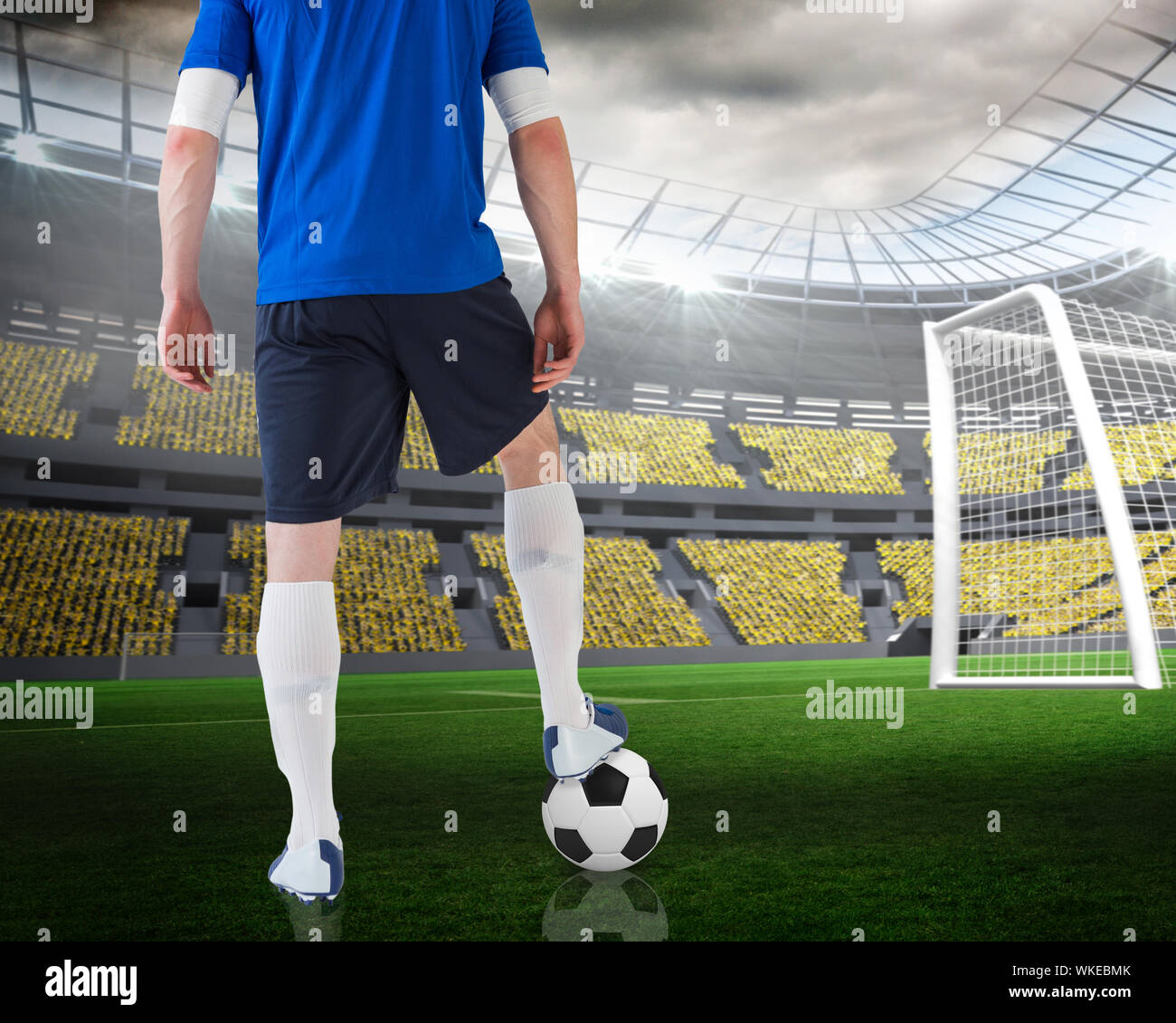 Composite image of football player standing with ball against large ...