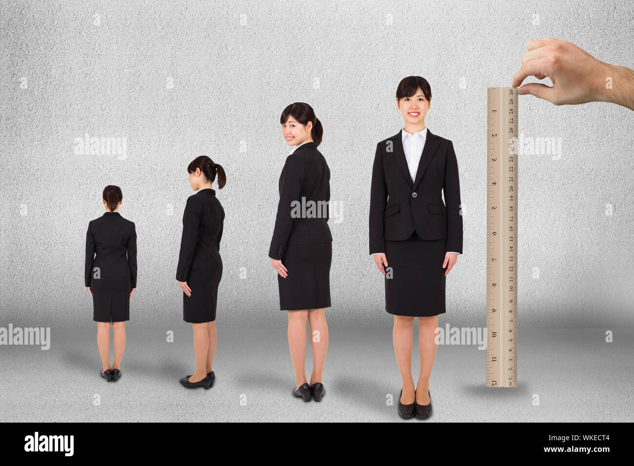 Composite image of hand measuring businesswoman with ruler against grey ...