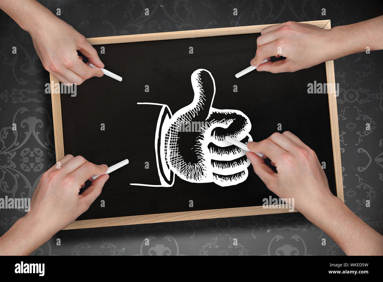Composite image of multiple hands drawing thumb up with chalk against ...