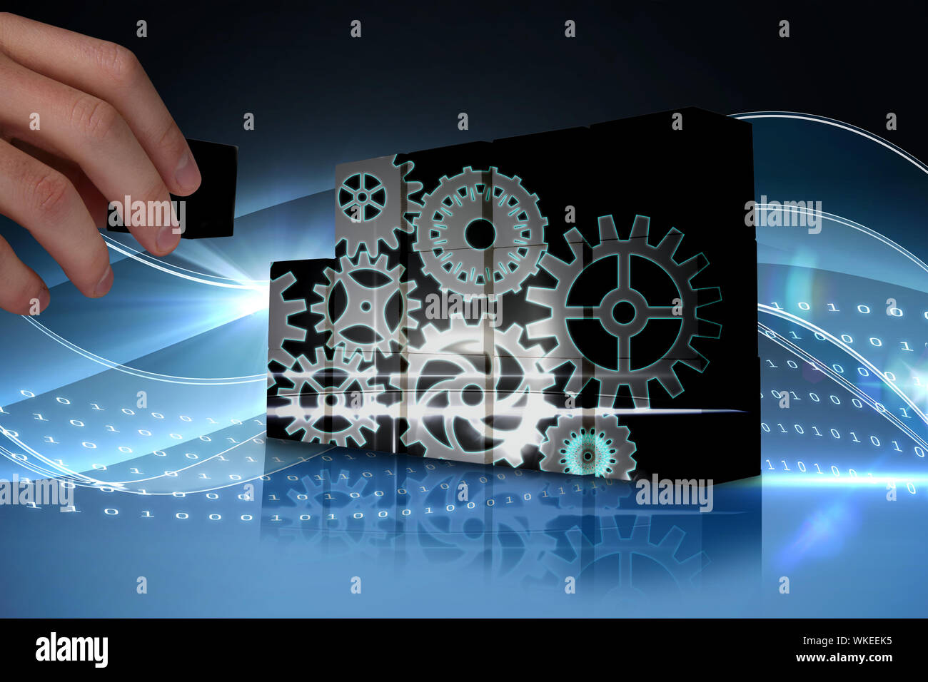 Hand building wall showing cogs and wheels graphic Stock Photo - Alamy