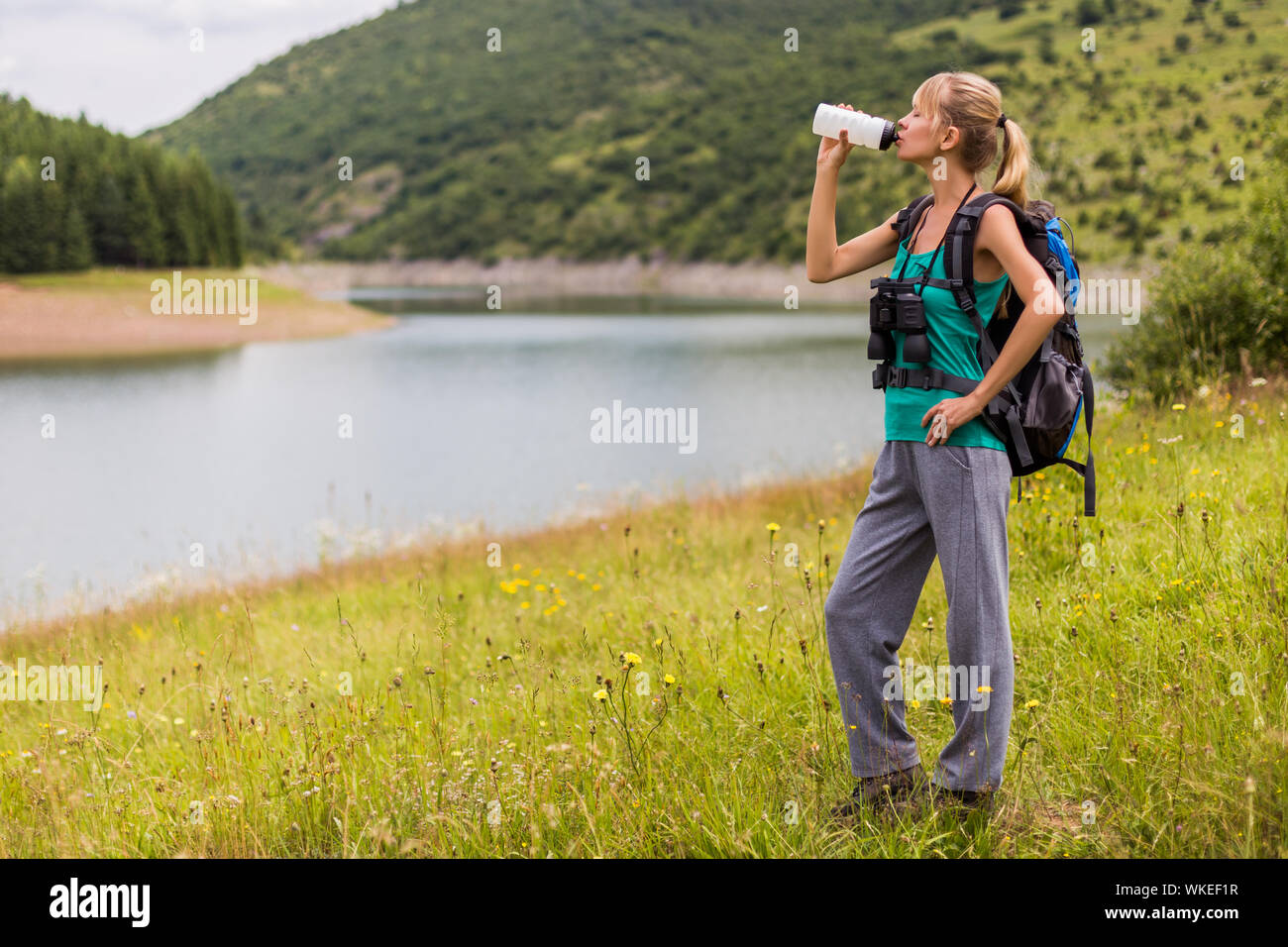 Woman hiker standing drinking water hi-res stock photography and images ...