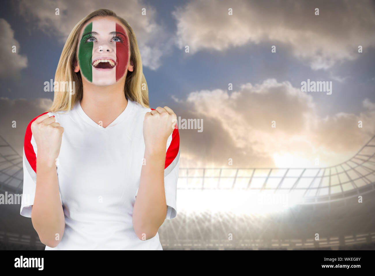 Excited italy fan in face paint cheering against large football stadium ...
