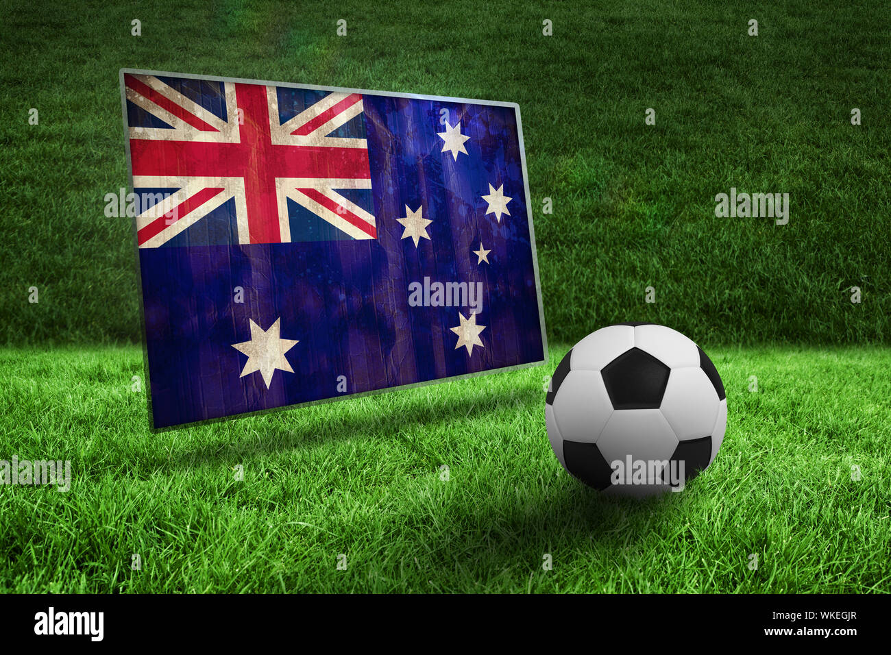 Black and white football on grass against australia flag in grunge ...
