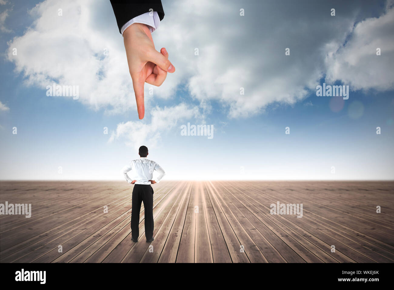 Giant hand pointing at businessman standing back to the camera with ...