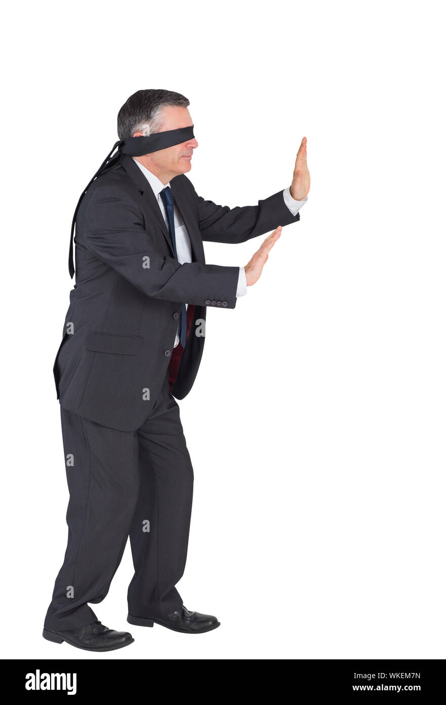 Mature businessman walking with blindfold on white background Stock ...
