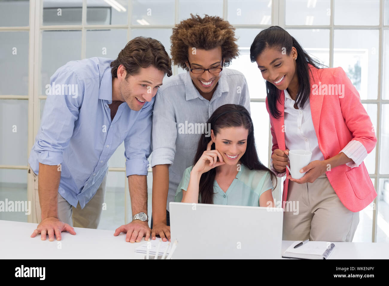 Coworkers interacting with laptop computer in the office Stock Photo ...