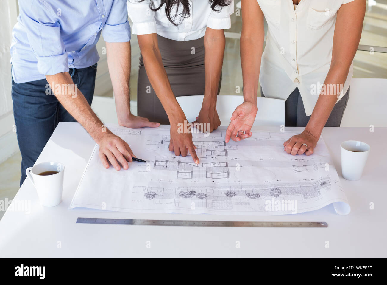 Group of architects working on blueprints in the office Stock Photo - Alamy