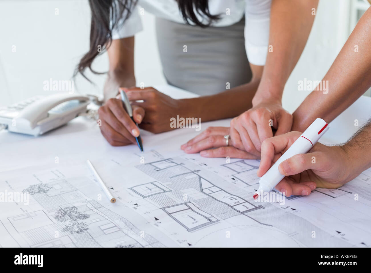 Coworkers working on blueprints together in the office Stock Photo - Alamy