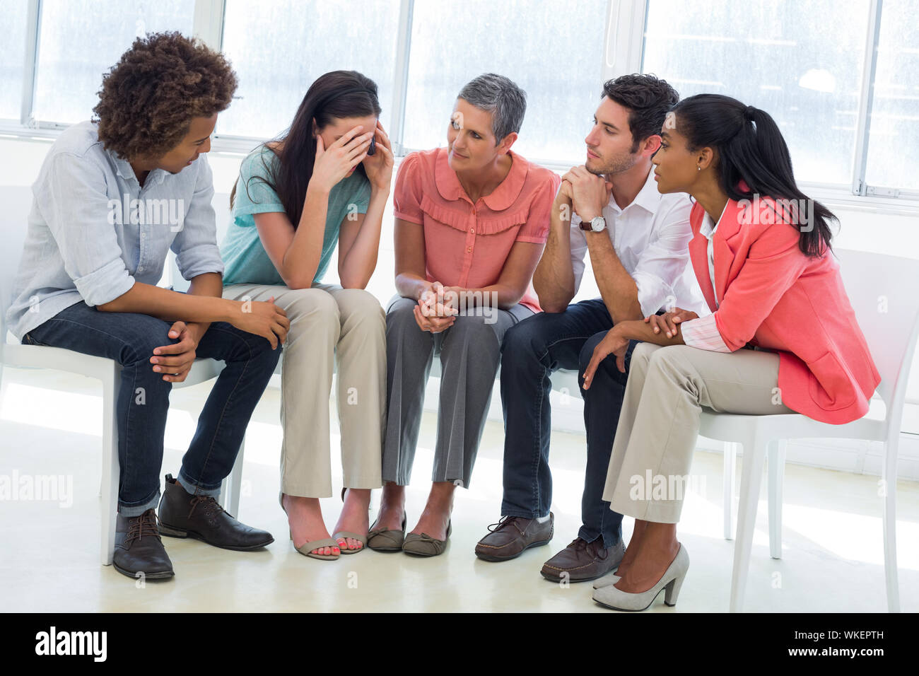 Group therapy in session sitting in a circle in a bright room Stock ...