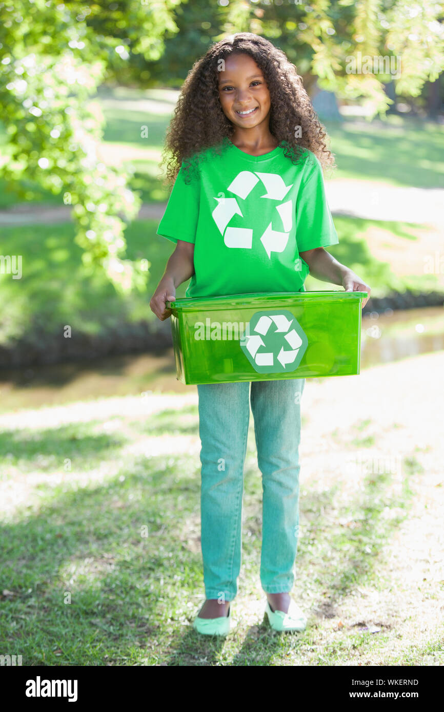 on a sunny Young environmental activist smiling at the camera holding ...