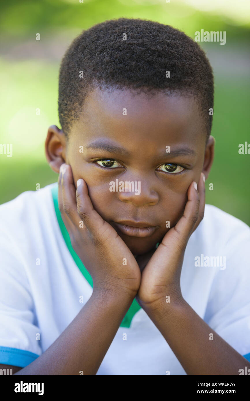 Cute boy pouting at the camera in the park on a sunny day Stock Photo ...