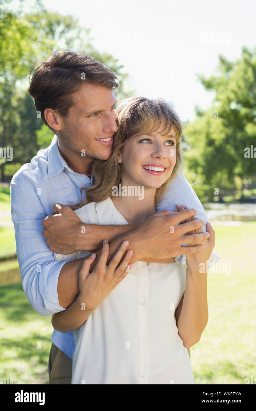 Cute couple hugging in the park and smiling on a sunny day Stock Photo ...