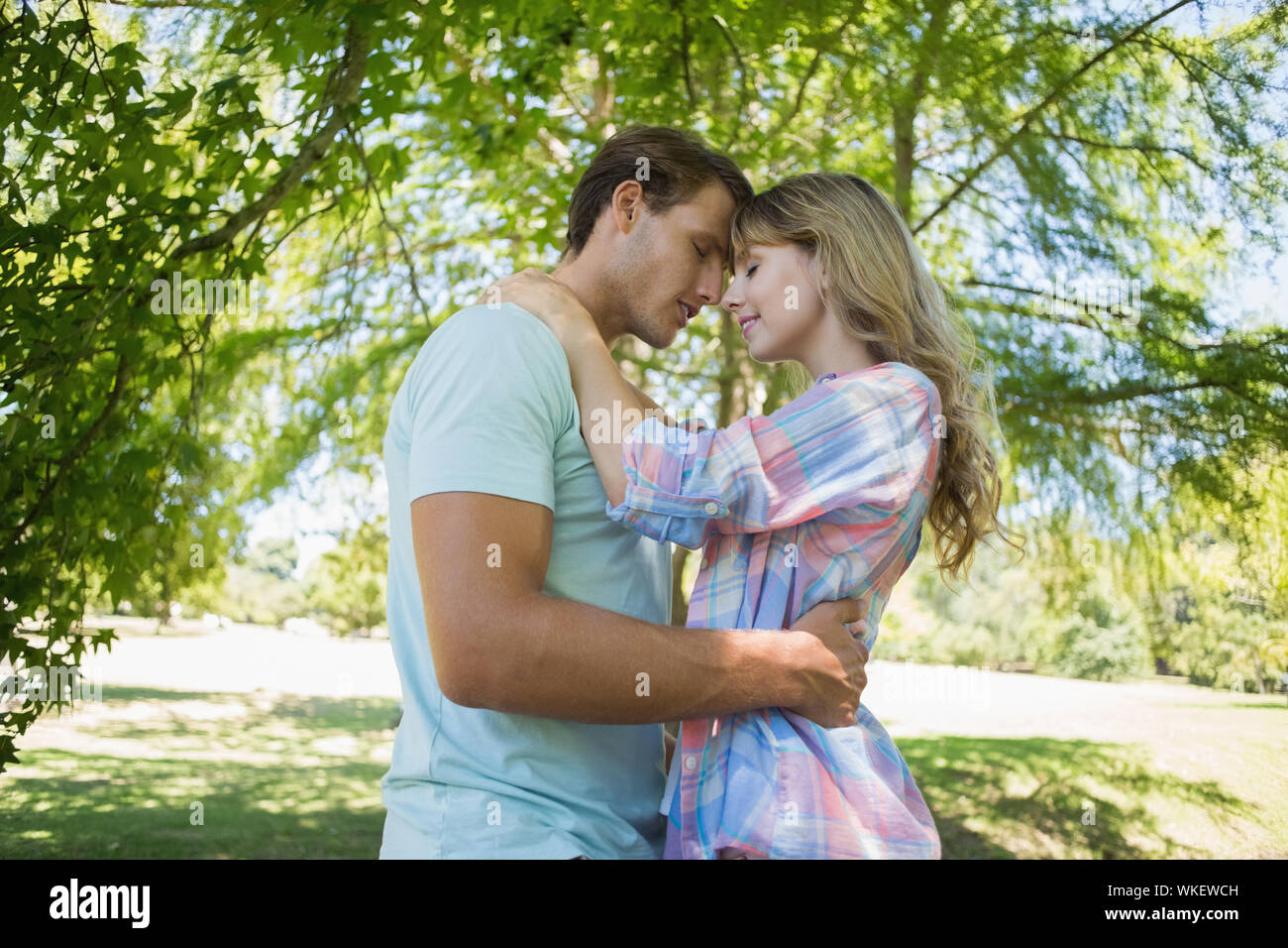Cute affectionate couple hugging in the park on a sunny day Stock Photo ...