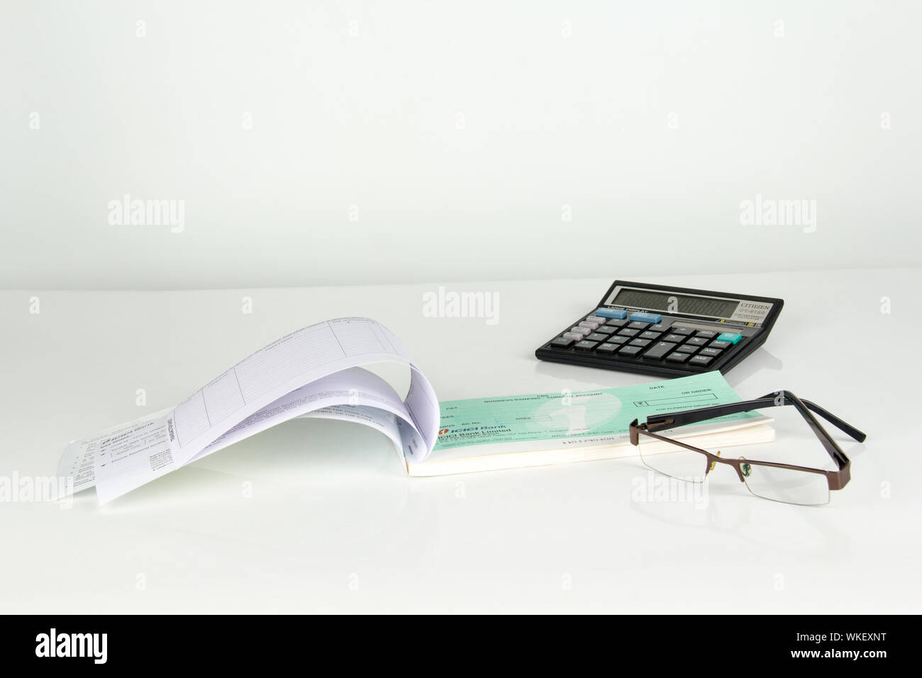 Empty cheque book with calculator and eyeglasses Stock Photo - Alamy