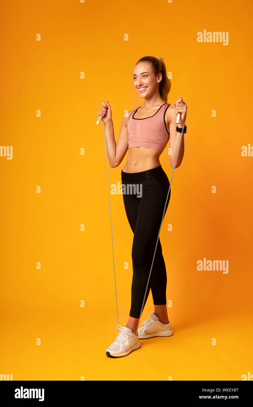Girl Doing Jump Rope Workout Over Yellow Background Stock Photo - Alamy